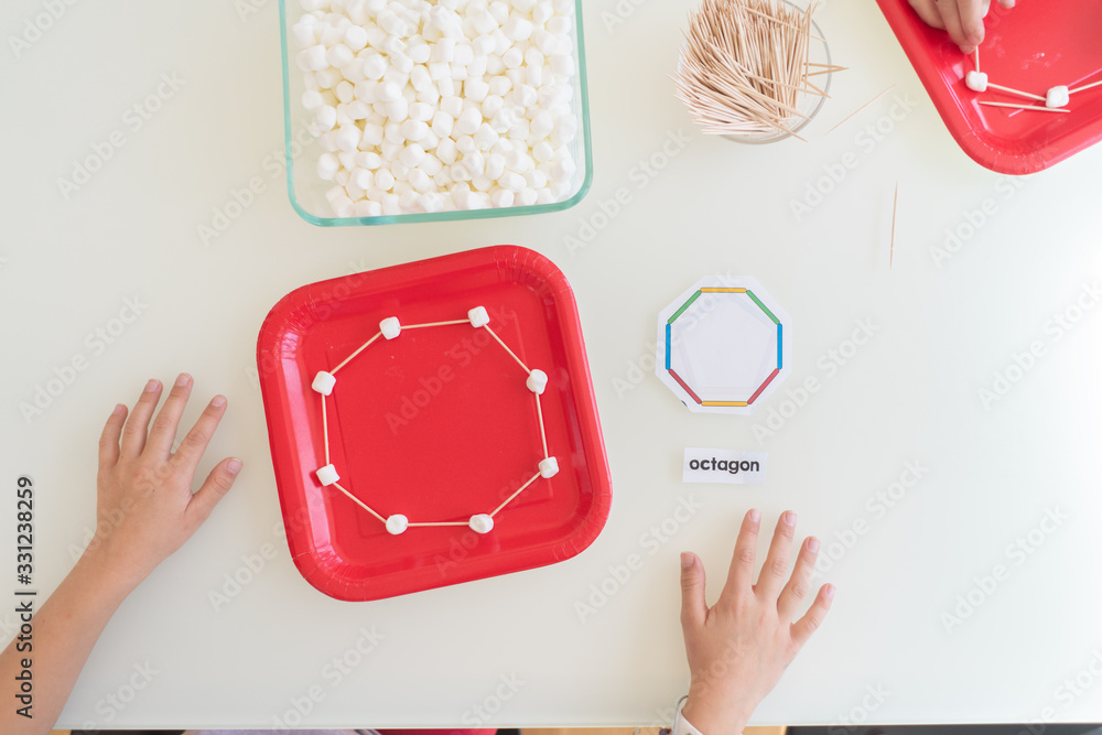 Foto de Stock Directly above view of young children making geometric ...