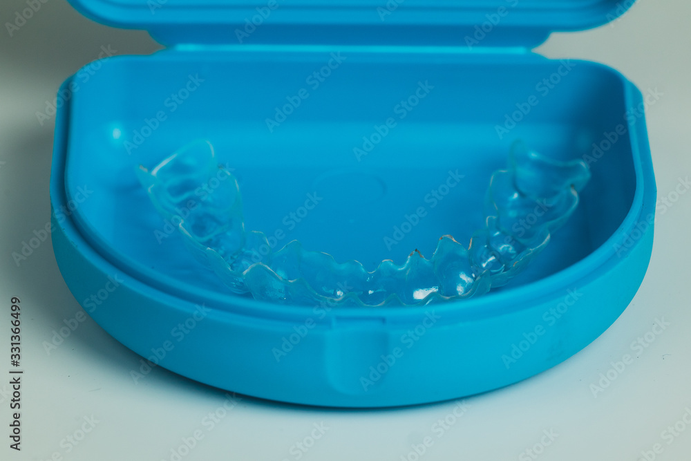Orthodontic retainer made from transparent plastic in a blue carrying ...