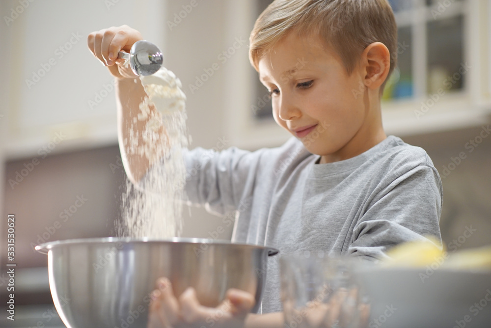 Child cooking at the kitchen. White boy stirring dough for a cookie ...