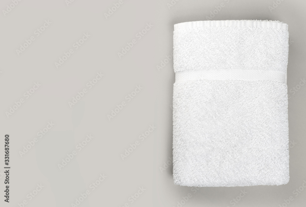 Top view of folded clean white bathroom towel on gray background with ...