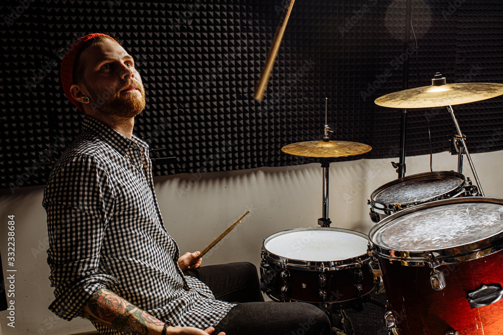 young caucasian drummer rehearsing on drums before rock concert ...