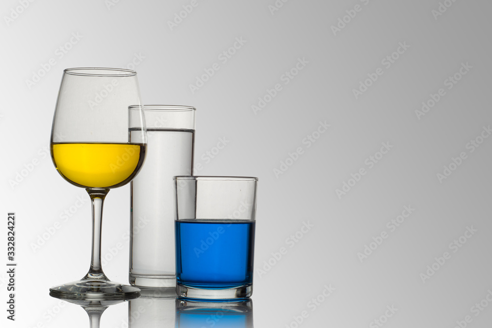 Copa y vasos de cristal con un fondo blanco y bebidas de diferentes ...