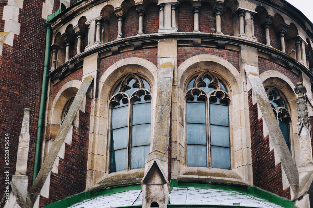 Old pointed gothic windows with stained glass on facade of the building ...