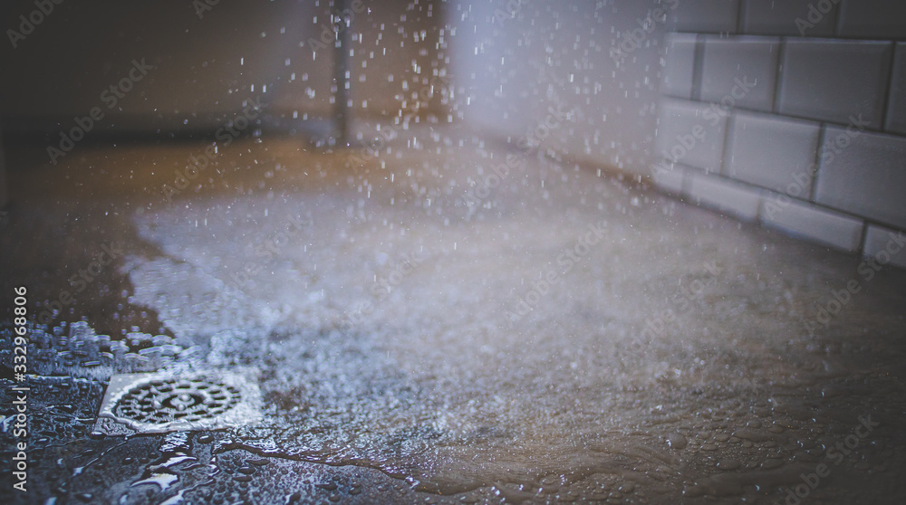 Close up image of water from a shower falling on a shower floor in a ...