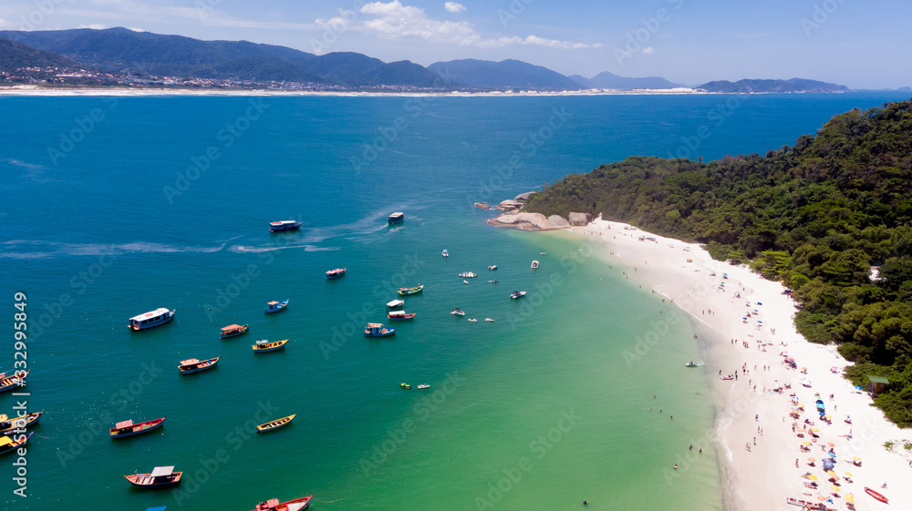 Imagem aerea de ilha com barcos ancorados praia cheia e o continente ...