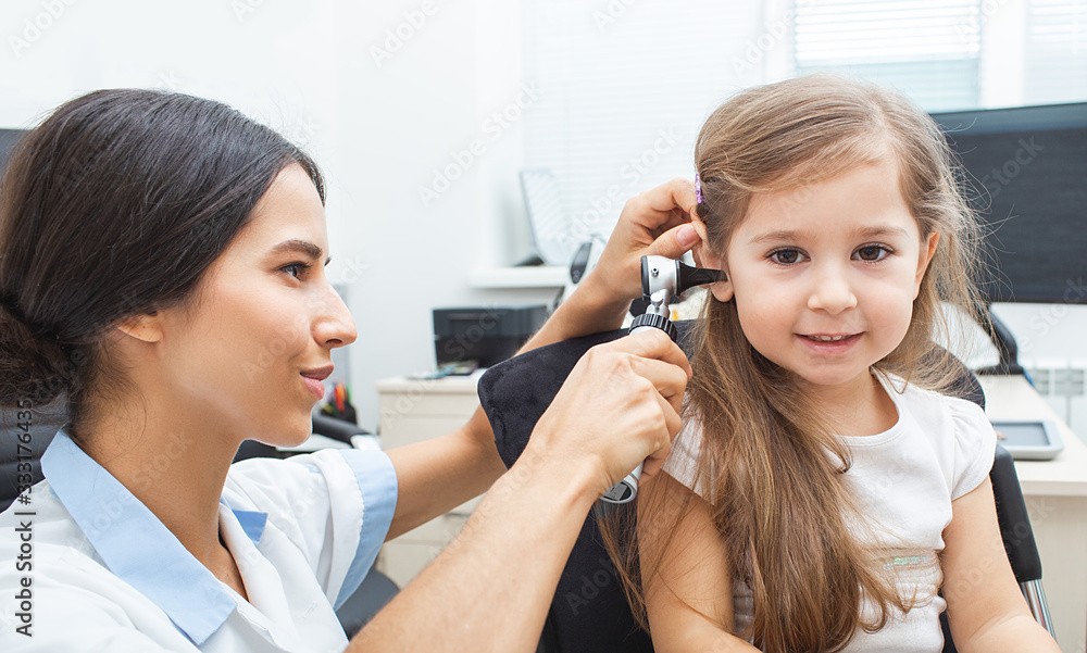 ENT doctor doing an ear exam with otoscope to little girl. Hearing ...