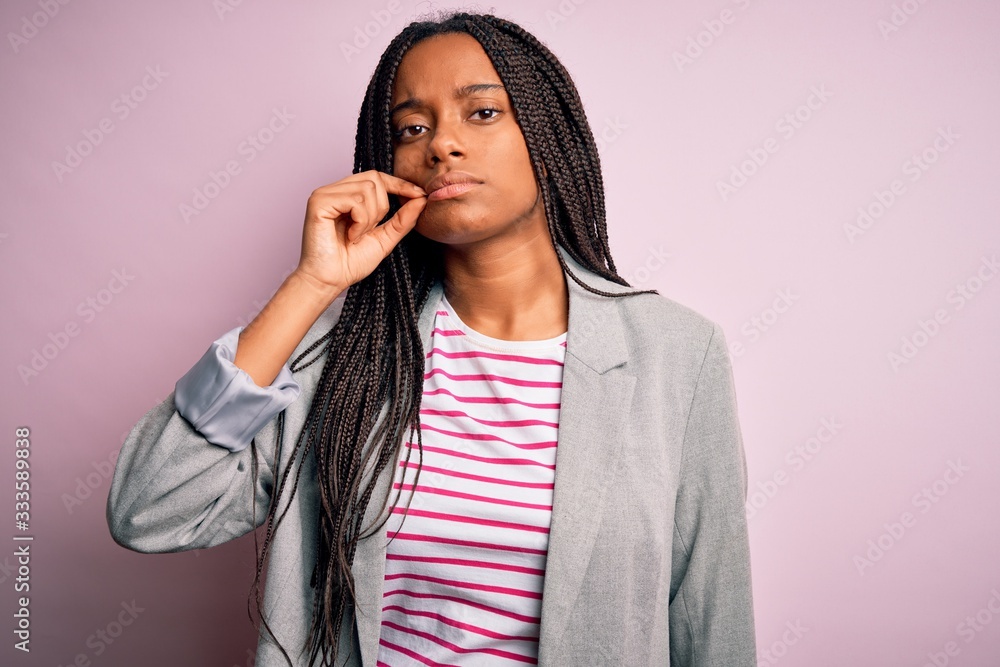 Young african american business woman standing over pink isolated ...