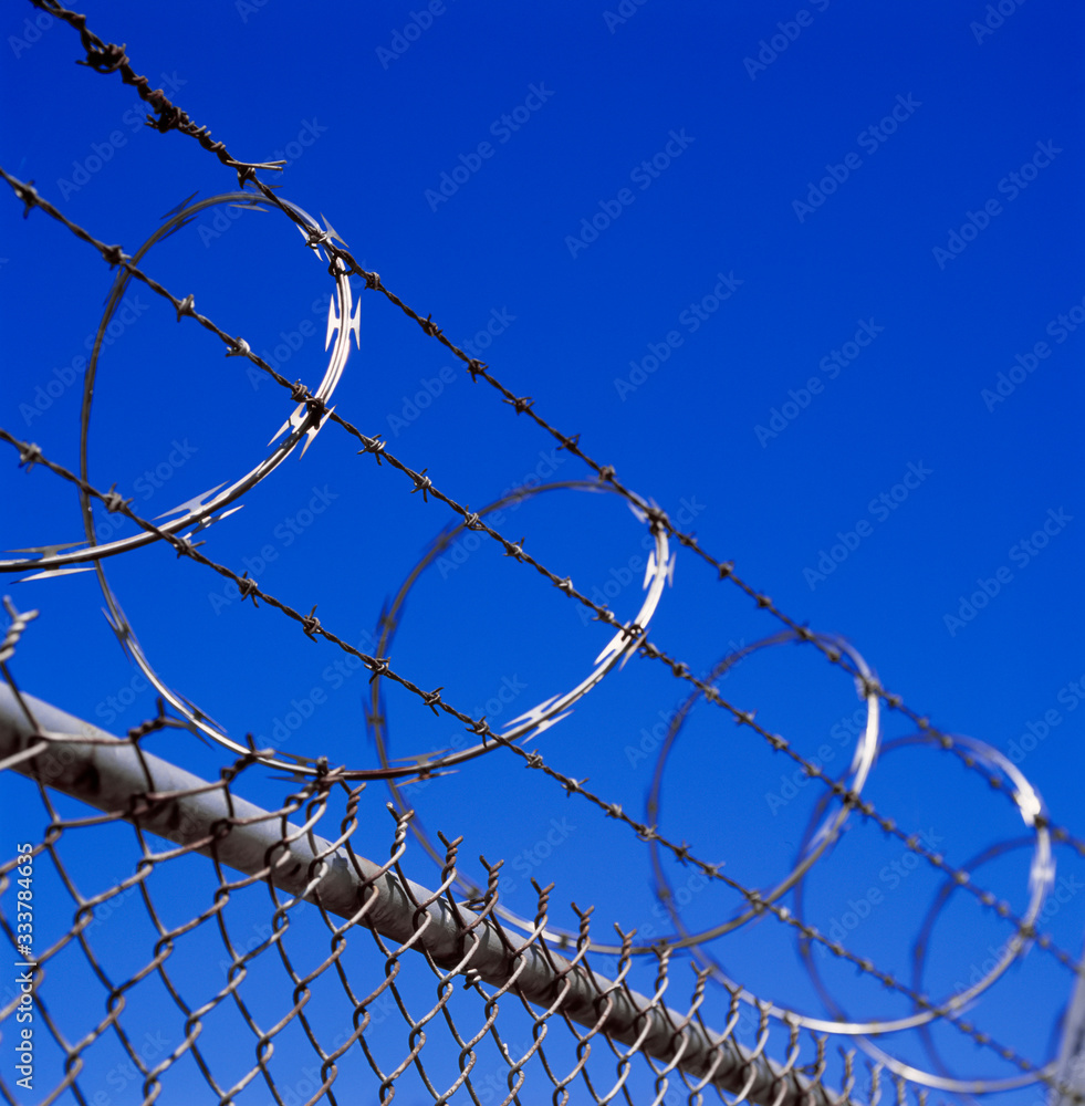 Barbed wire and razor wire on chain link fence. Security, prison ...