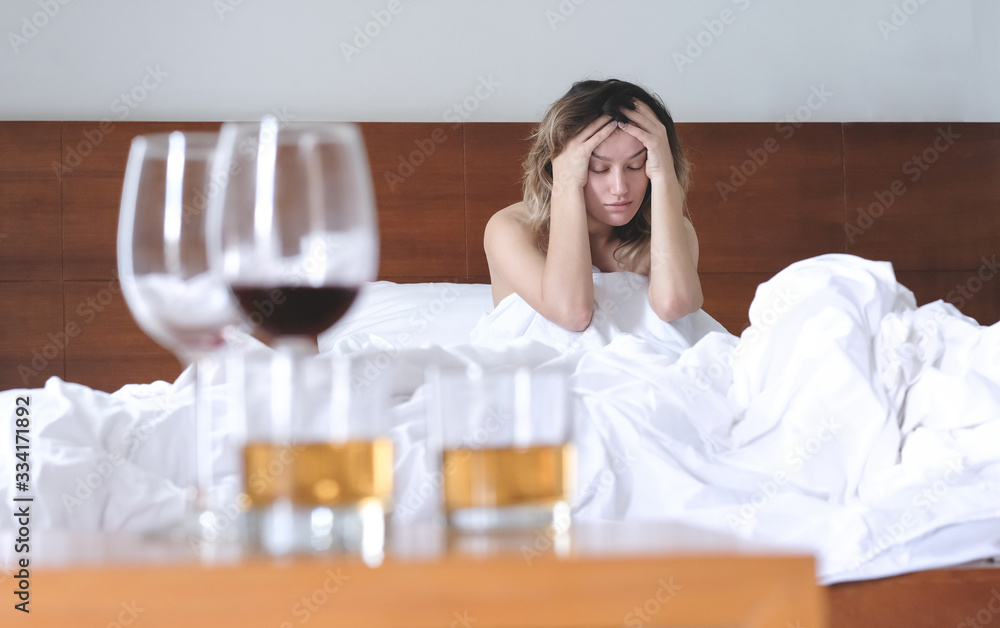 Young exhausted wasted woman waking up suffering headache and hangover ...