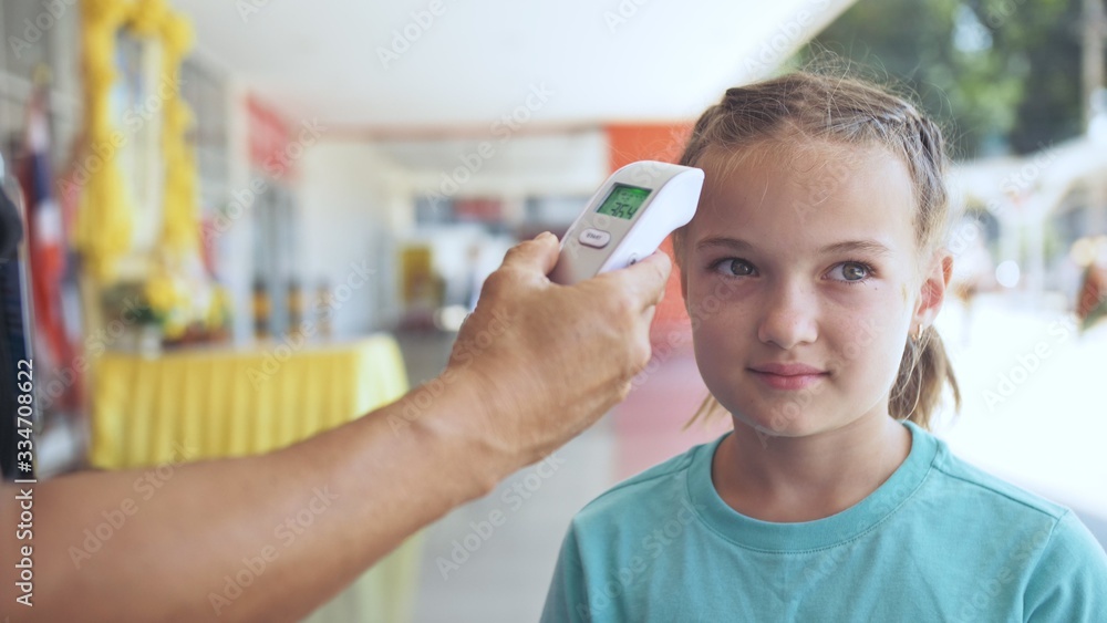 Temperature check at a supermarket of little girl, grocery store with ...