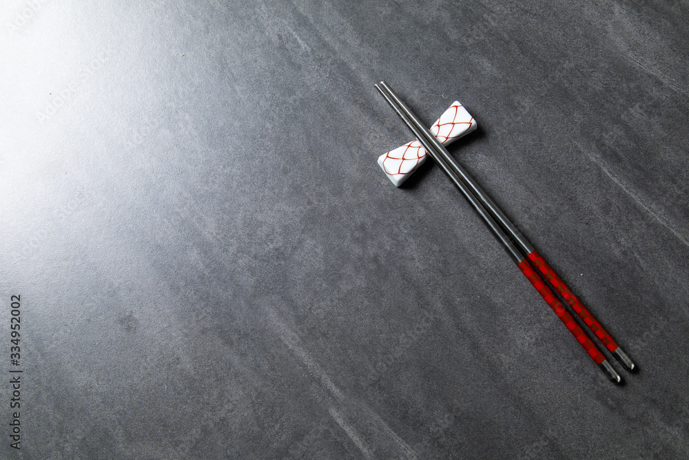 Steel chopsticks with holder on black stone background. Chinese ...