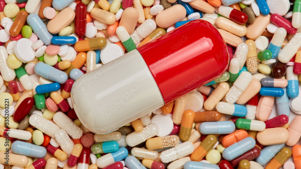 Colorful big capsule on small medication Stock Photo | Adobe Stock