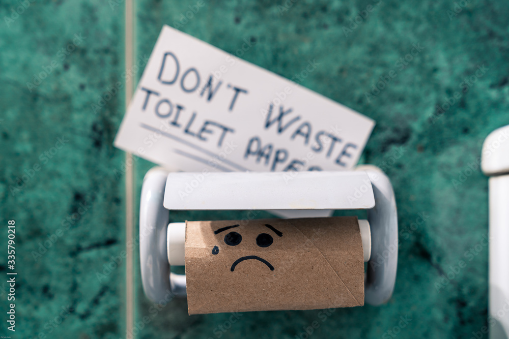 Toilet paper roll finished in the bathroom with a picture of a sad face ...