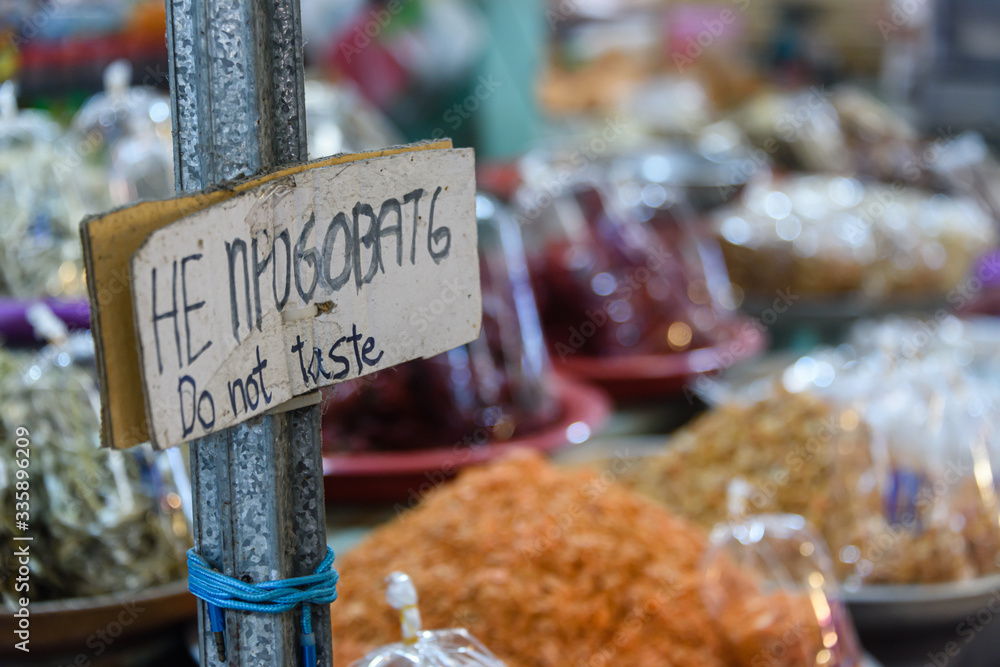Sign saying "Do not taste" in Thai and English at a food market stall ...