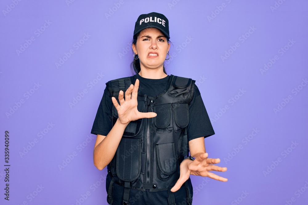 Young police woman wearing security bulletproof vest uniform over ...