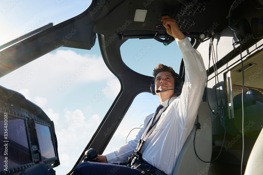 Male Pilot In Cockpit Of Helicopter Doing Pre Flight Check Before Take ...