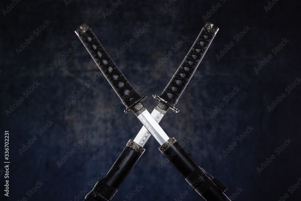 Two crossed katanas with partially drawn blades Stock Photo | Adobe Stock