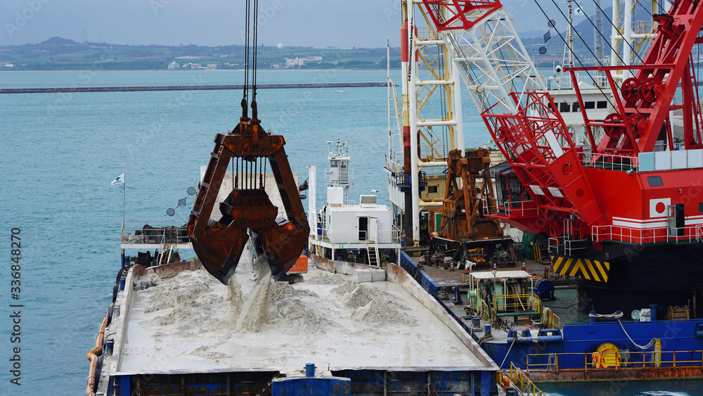 Huge excavator on floating platform in the blue water of the Pacific ...