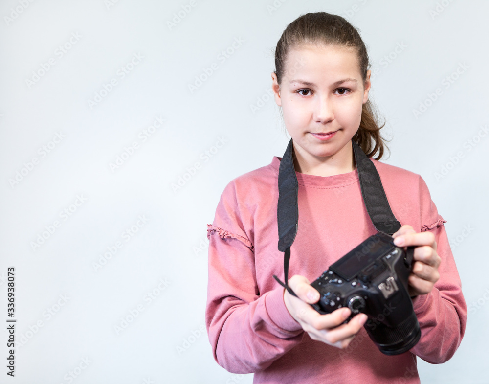 Young girl with professional dlsr camera in hands, portrait, looking at ...