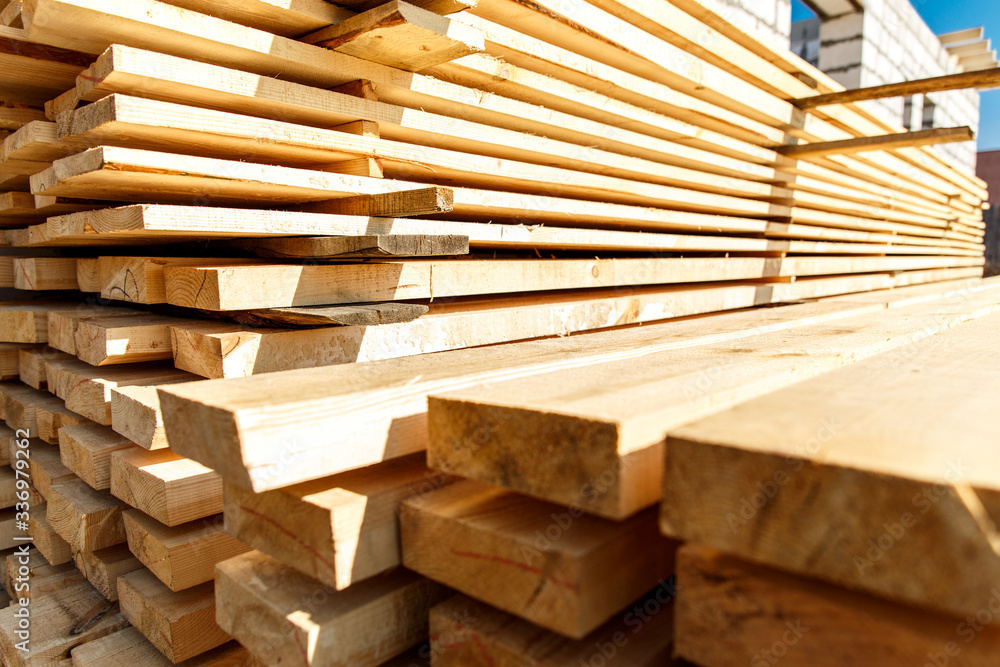 Stack of new wooden studs at the lumber yard. Timber on the ...