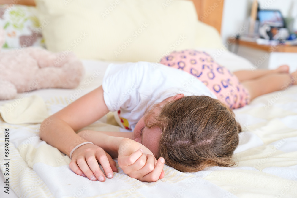 girl lying flopped on her bed Stock Photo | Adobe Stock
