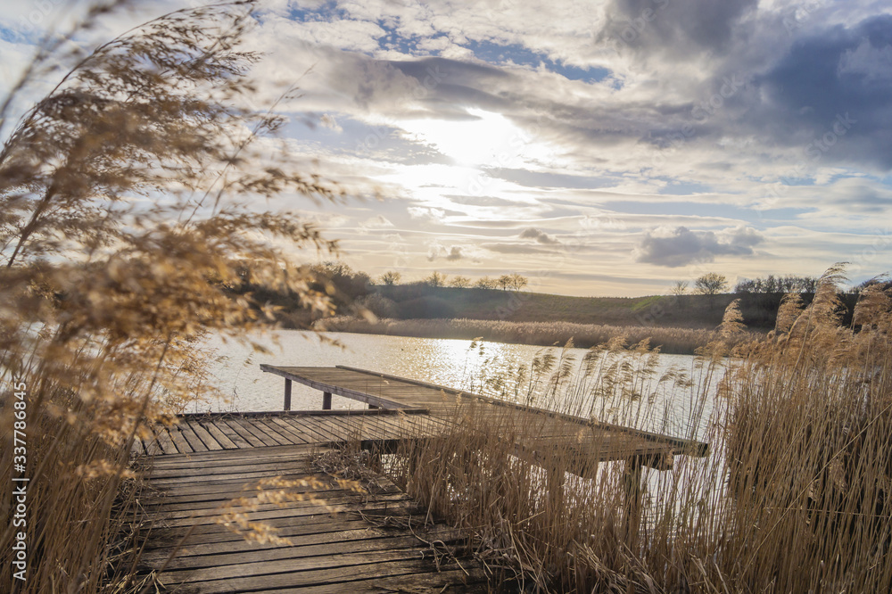 Ruhiger Seesteg im Abenddämmerung mit Wolken am Himmel. Warmes Licht ...