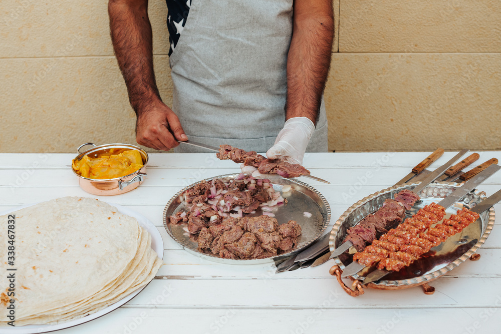 Process of making kebab. Meat on skewer. Cooker follow hygiene and use ...