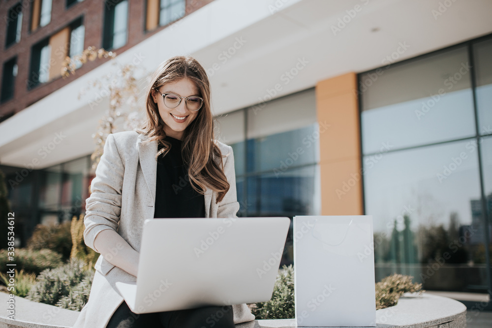 Beautiful lady with laptop and shopping bags, making online orders ...