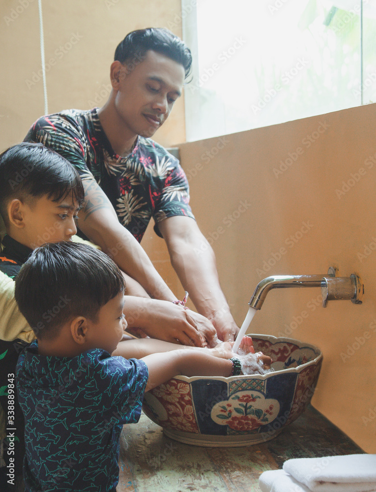 Asian family washing hands with soap in bathroom. Indonesian, malasian ...
