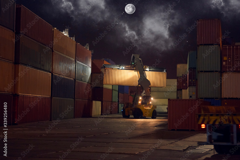 reach stacker puts container in stack. industrial port with containers ...