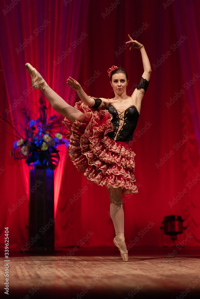 Young girl ballerina in red spanish flamenco costume performs with a ...