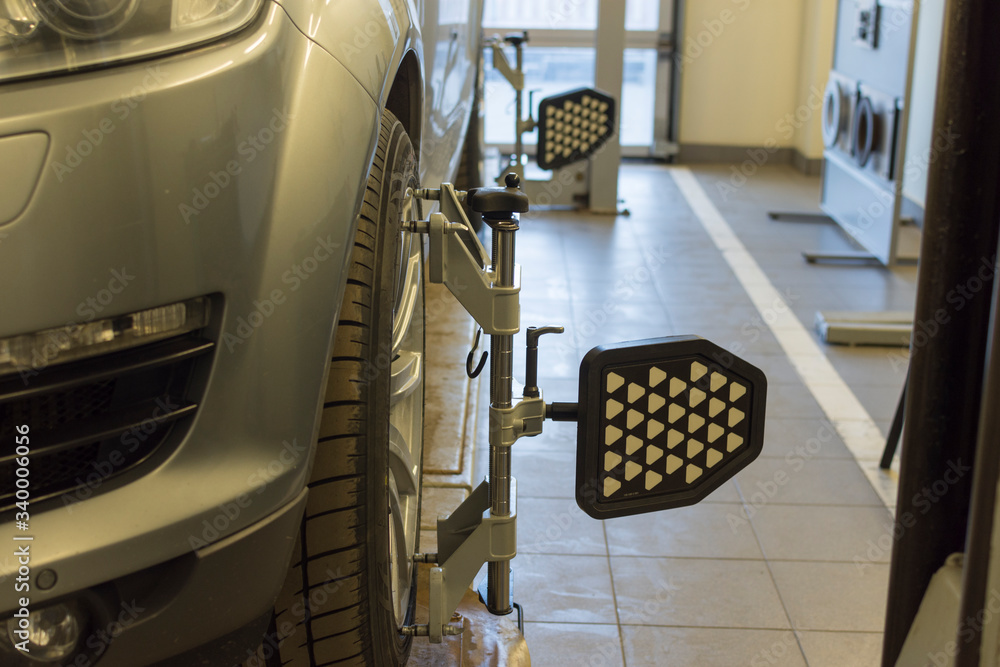 Car on stand with sensors on wheels for wheels alignment camber check ...