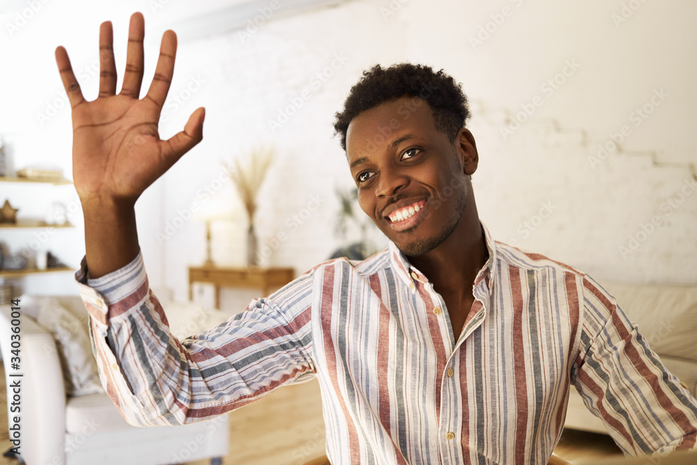 Horizontal image of casually dressed positive young African man making ...