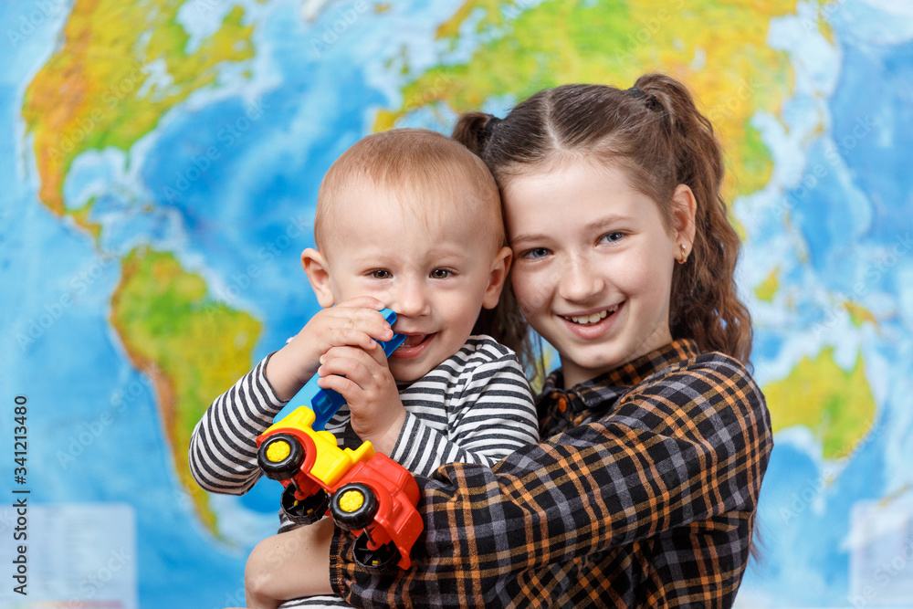 Beautiful teenage girl hugs little brother with a typewriter in his ...