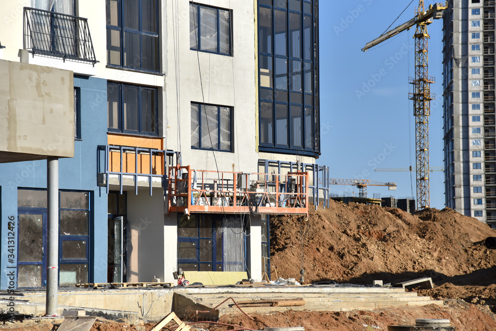 Suspended construction cradle on the background facade of the building ...