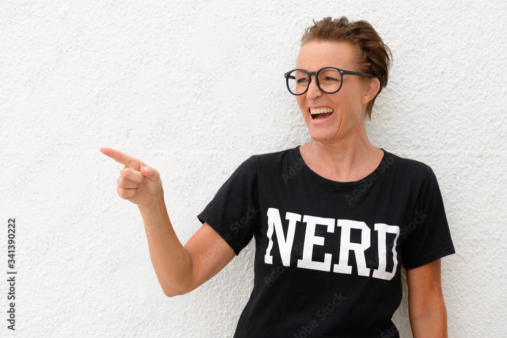 Mature nerd woman wearing big eyeglasses and standing against white ...