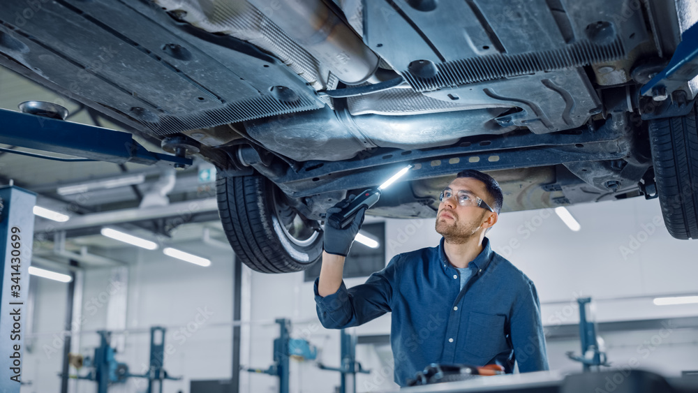 Handsome Professional Car Mechanic is Investigating Rust Under a ...