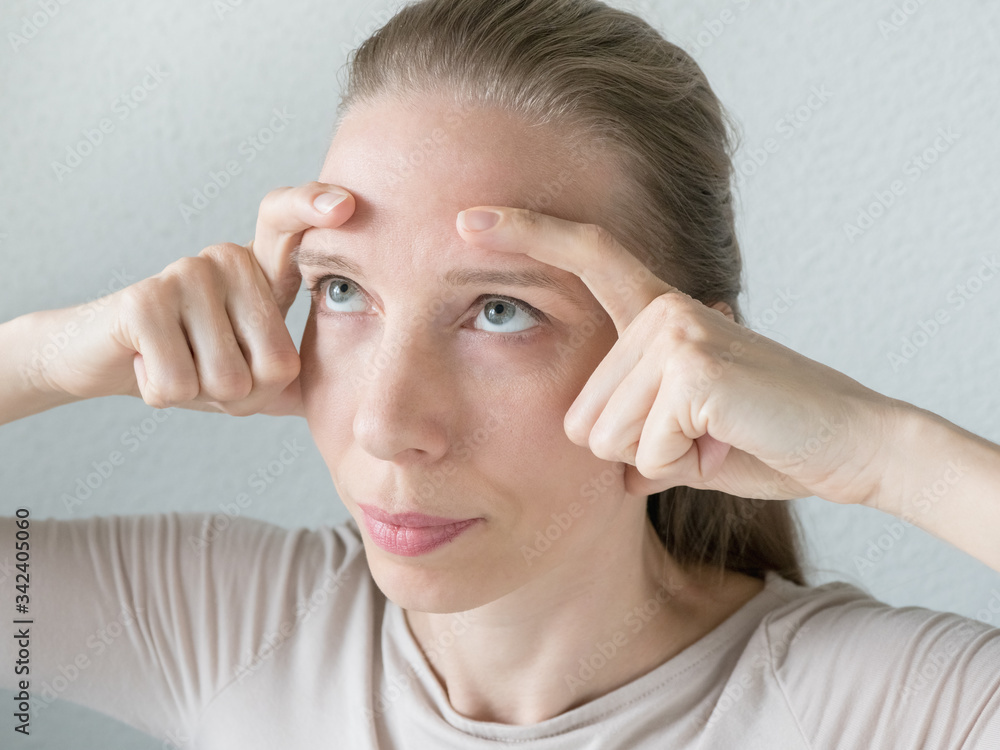 Gymnastics for the face. Woman does rejuvenating exercises for the face ...