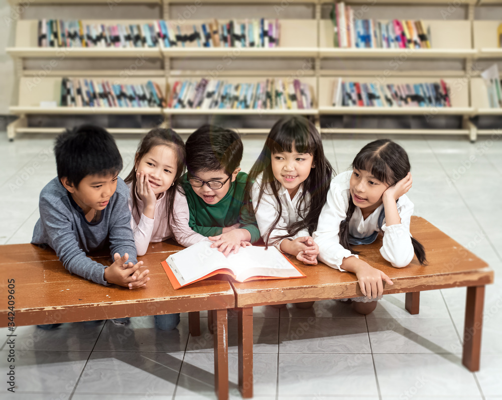 Five little childre sitting beside wood table,reading book and talking ...