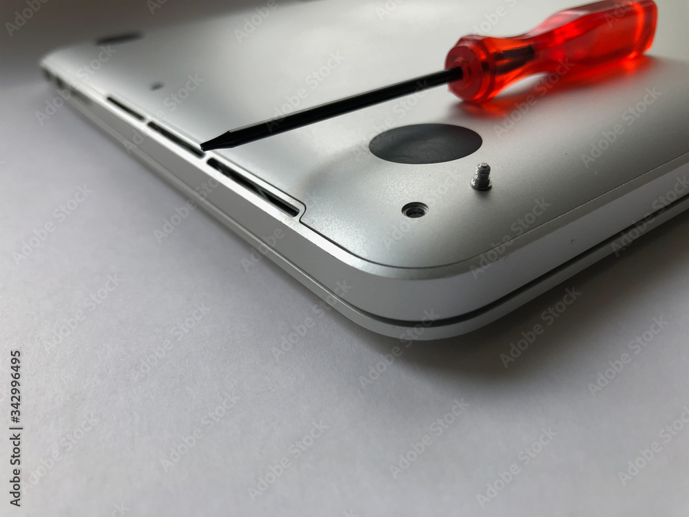 Back side of silver MacBook Pro 13 with a red screwdriver. Laptop ...
