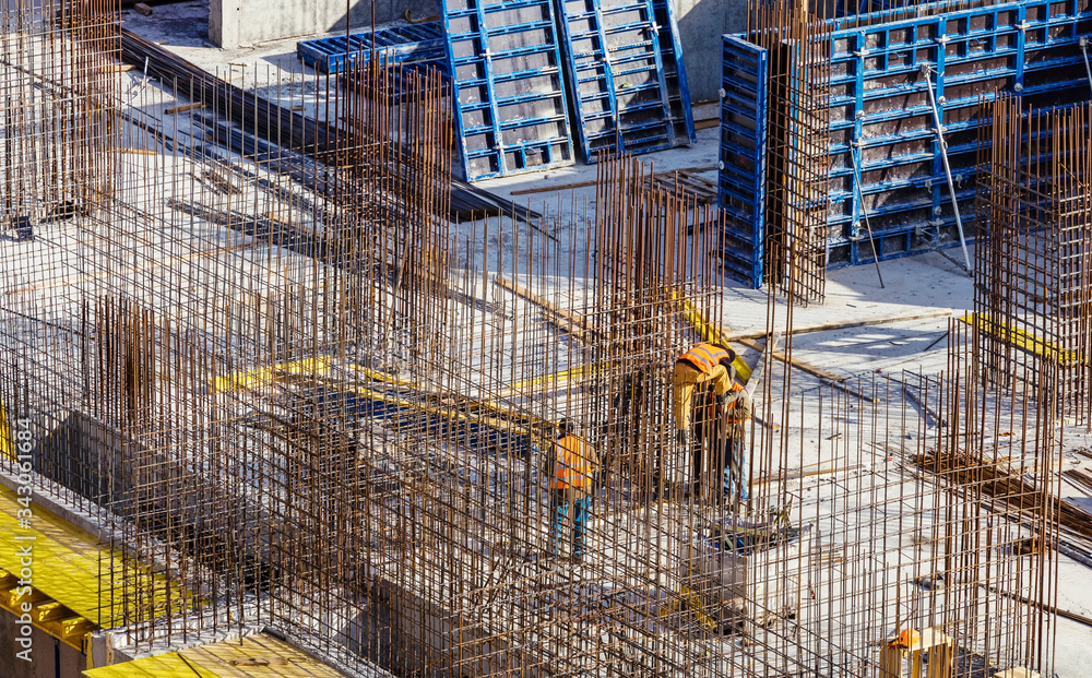 Construction workers install formwork and iron rebars or reinforcing ...