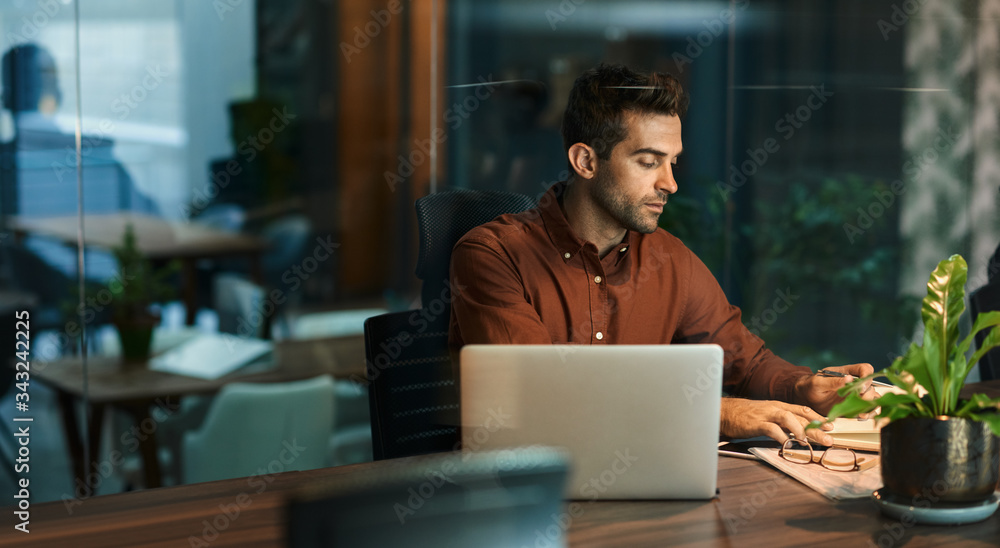 Businessman working alone in an office at night Stock Photo | Adobe Stock