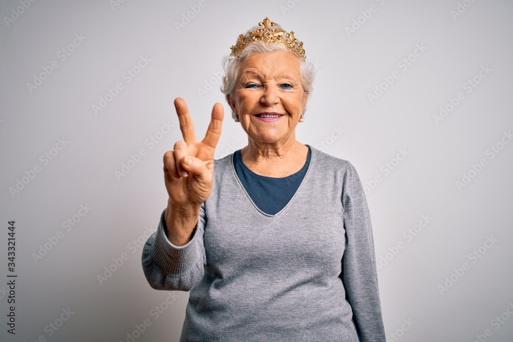 Senior beautiful grey-haired woman wearing golden queen crown over ...