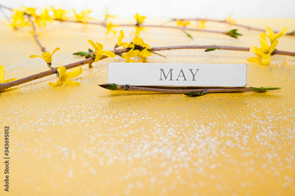 lettering May on a piece of wood with a bouquet of yellow spring ...