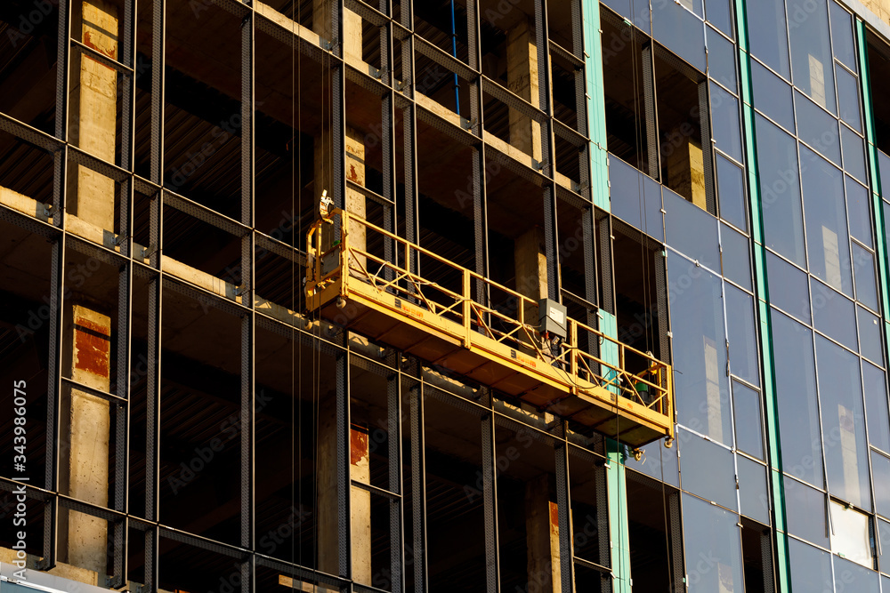 Suspended construction craddle near wall of hightower building with ...