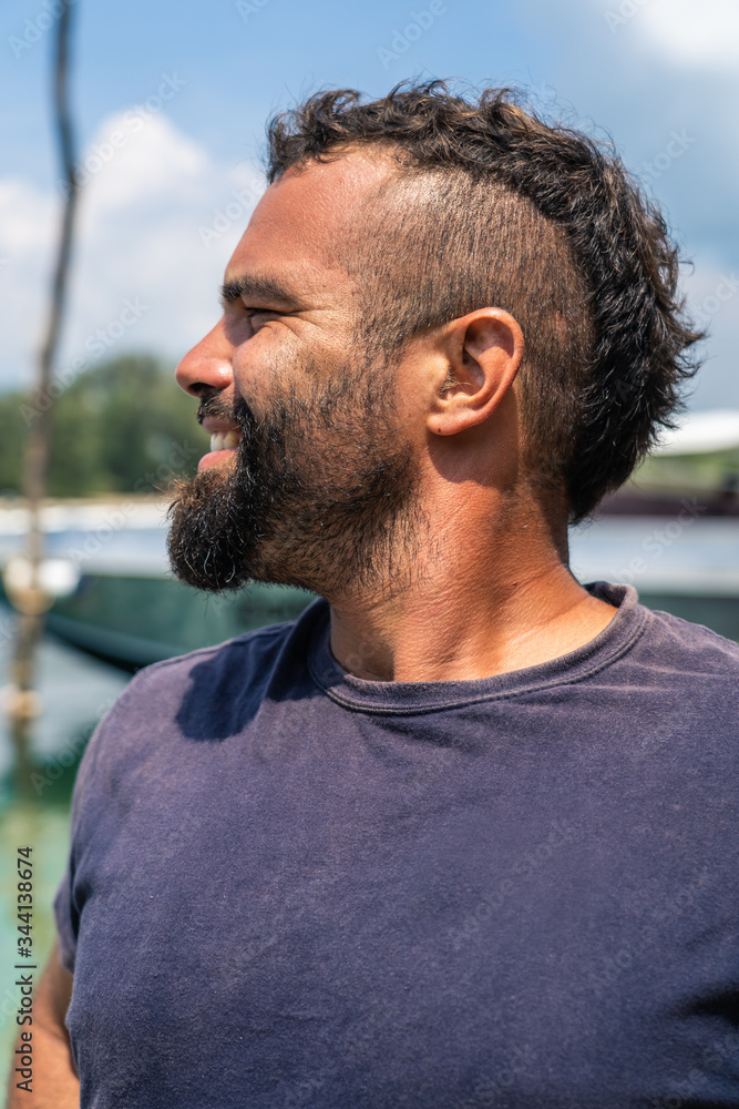 Smiling young man with mohawk and beard. Stock Photo | Adobe Stock