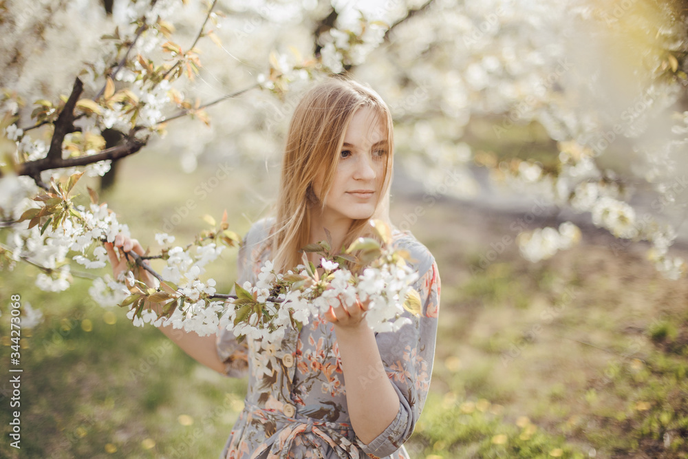 Girl in a flowering garden. Spring garden. Cheerful girl between trees ...