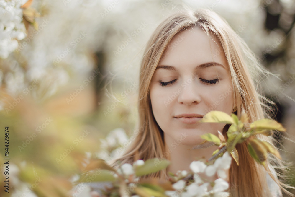 Girl in a flowering garden. Spring garden. Cheerful girl between trees ...