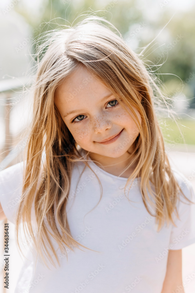 Little cute girl with freckles smiling, looking to camera, outdoors. Stock Photo | Adobe Stock