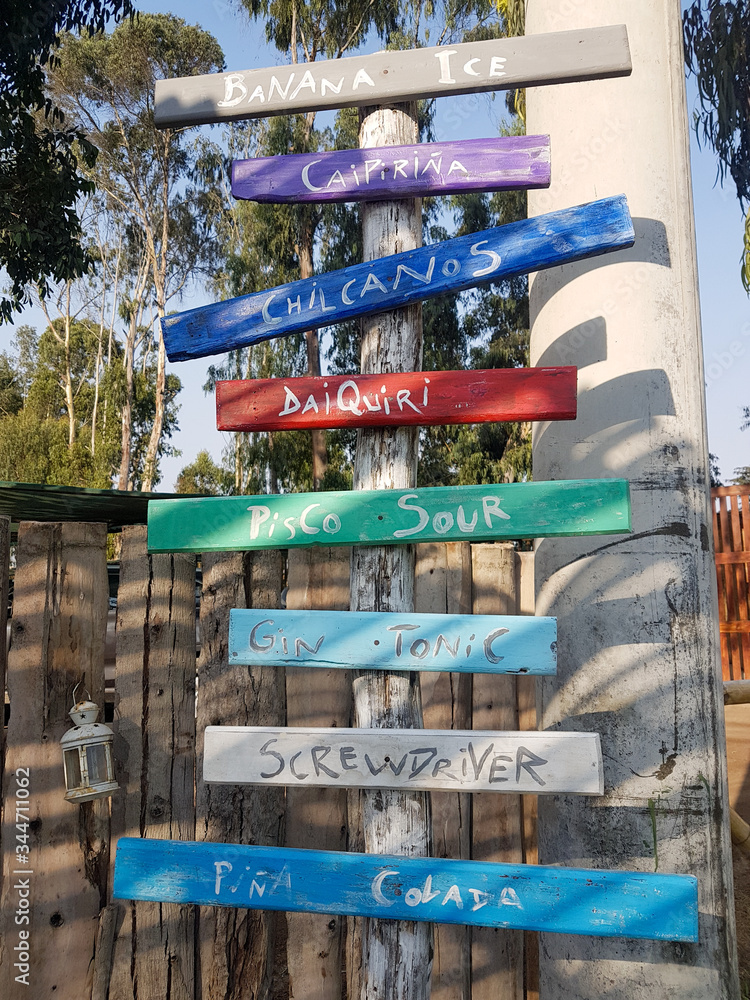 Wooden sign with name of drinks and refreshments on the sandy beach ...
